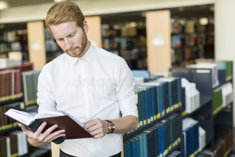 Young man in the library stock photo. Image of indoors - 58715514