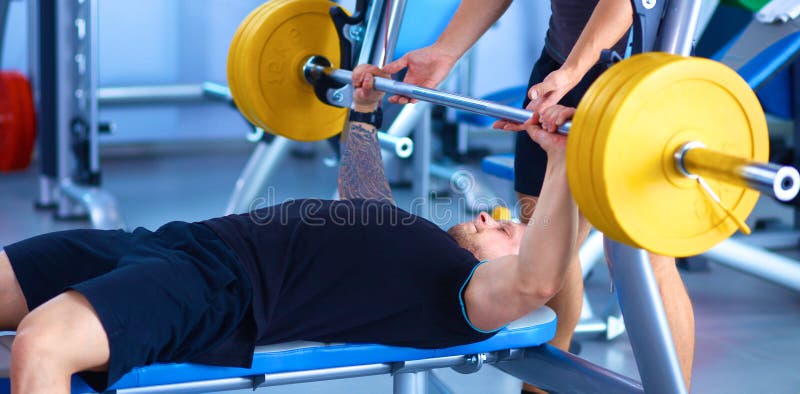 Young Man Lifting the Barbell in Gym with Instructor Stock Photo ...