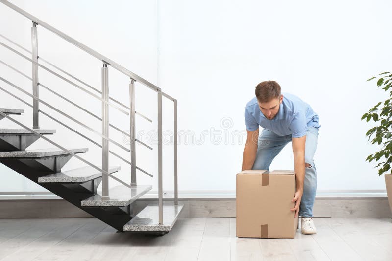 Young Man Lifting Carton Box Indoors Stock Image - Image of improper ...