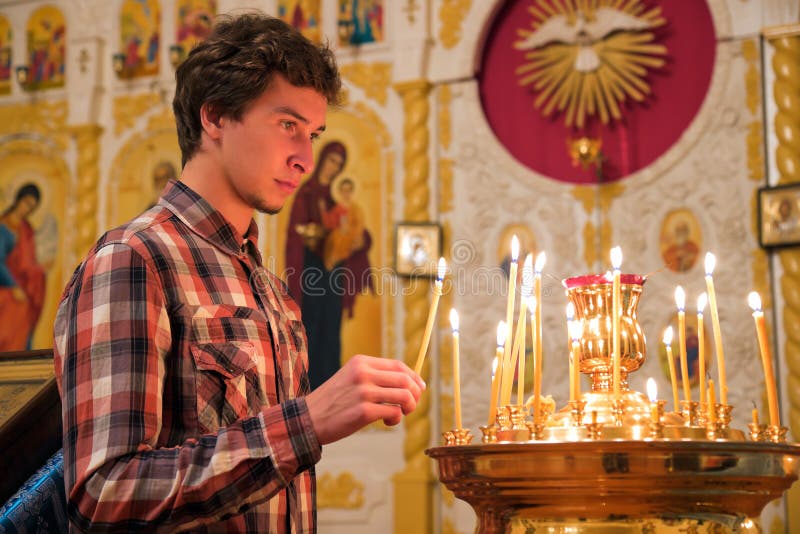 Young Man Lighting a Candle in the Church. Stock Photo - Image of flame ...
