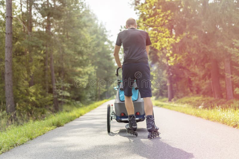Young Man in Line Skating Outdoors with Baby Stroller Stock Photo ...