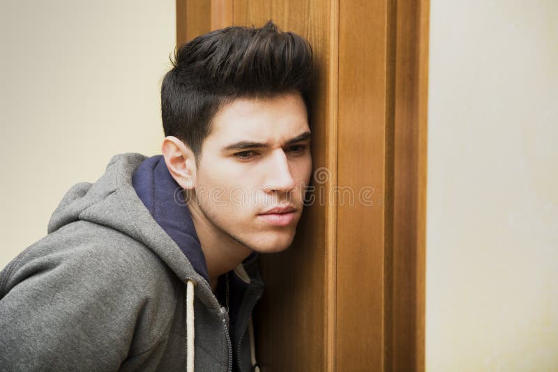 Young Man Listening in Behind a Door Stock Photo - Image of overheard ...