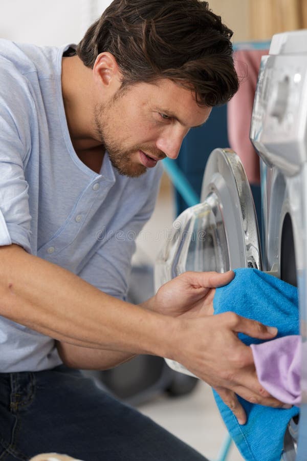 Young Man Loading Laundry into Washing Machine Stock Photo - Image of ...