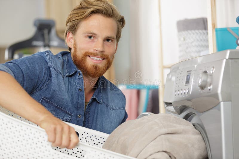Young Man Loads Laundry into Washing-machine Stock Photo - Image of ...