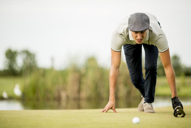Young Man Looking at Ball while Crouching on Golf Course Stock Image ...