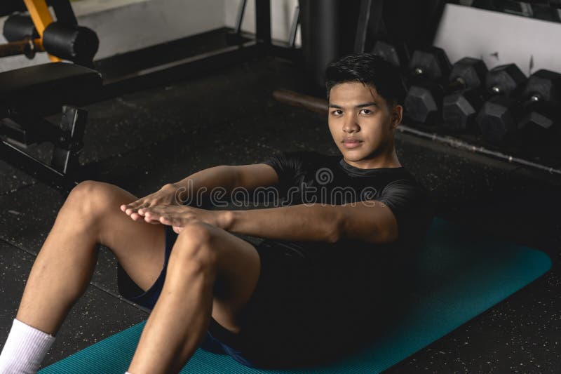 A Young Man Looking at the Camera while Doing Situps or Crunches with ...
