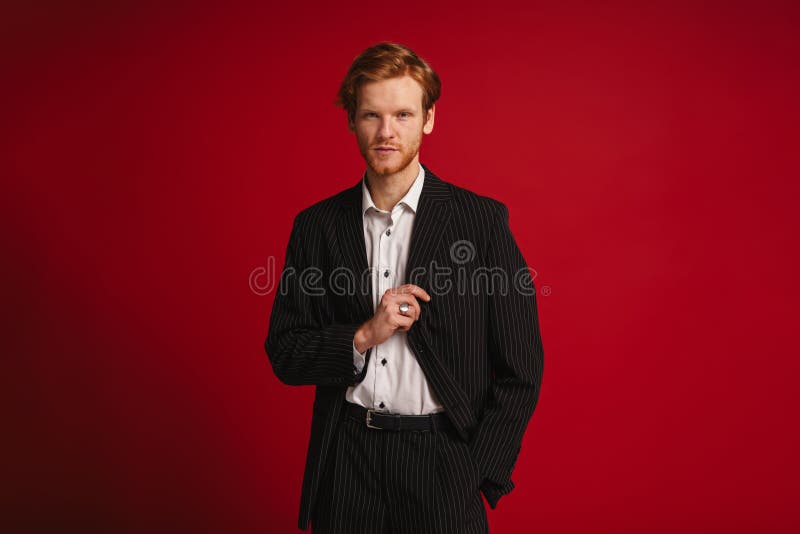 Young Man Looking at Camera while Standing Isolated Over Red Wall Stock ...