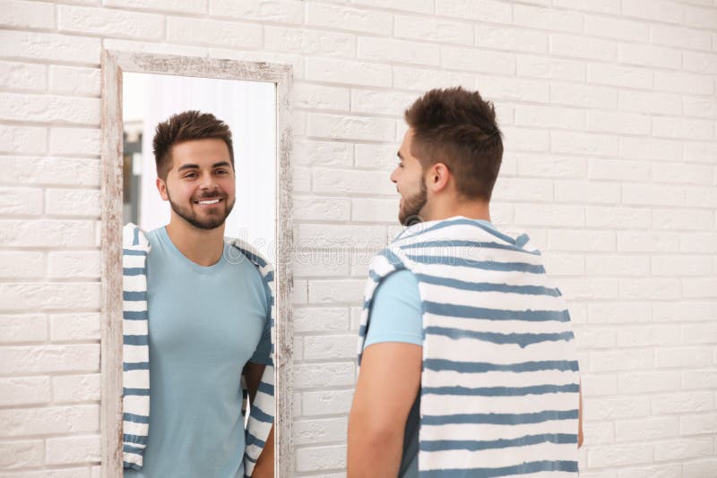 Man Looking at Himself in the Mirror in a Bathroom Stock Photo - Image ...