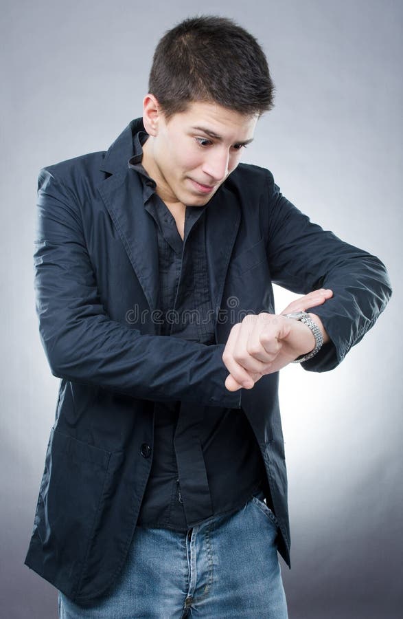 Young Man Looking at His Watch Stock Image - Image of gray, jeans: 28133335