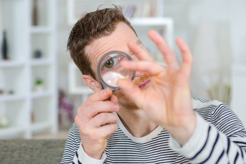 Young Man Looking through Magnifying Glass Stock Photo - Image of smile ...