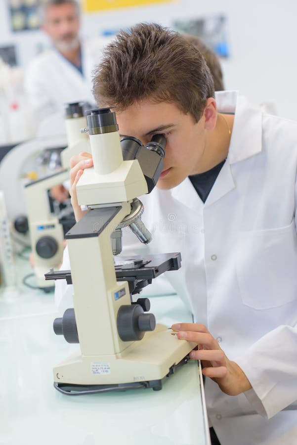 Man Looking through Microscope Young Lady Watching Stock Image - Image ...
