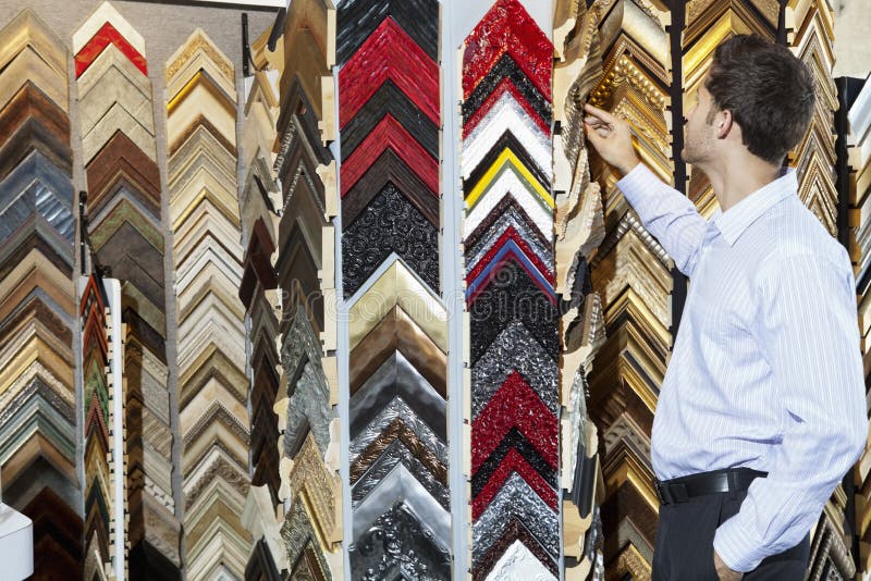 Young Man Looking at Multi Colored Frames in Store Stock Photo - Image ...