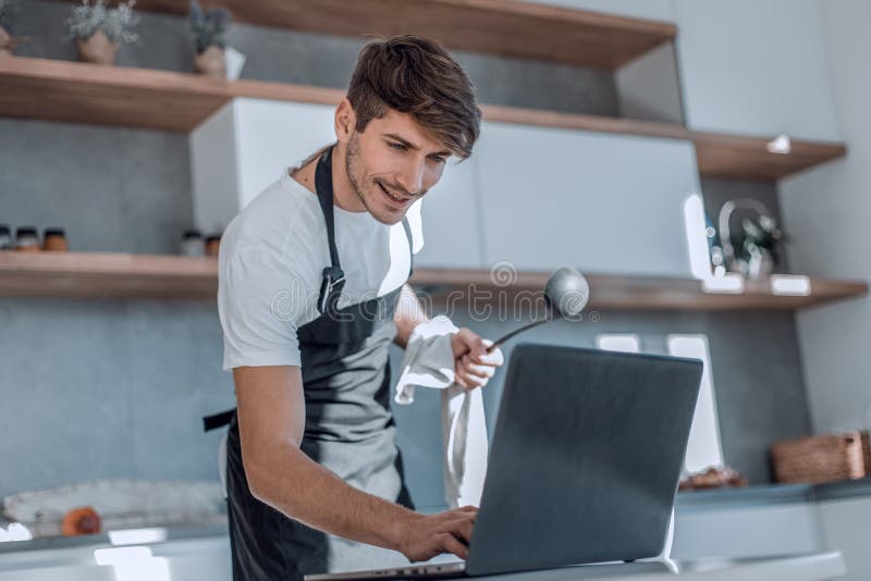 Young Man Looking at Recipe in Laptop while Cooking Dinner Stock Image ...