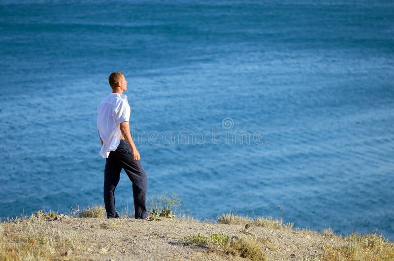 Young man looks at the sea stock photo. Image of vacation - 26397876