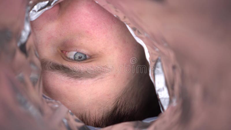 A Young Man Looks Suspiciously into an Empty Bag of Chips. First-person ...
