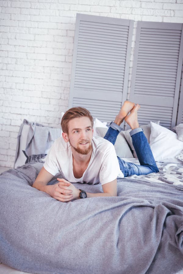 Young man lying in bed stock image. Image of leisure - 116784713