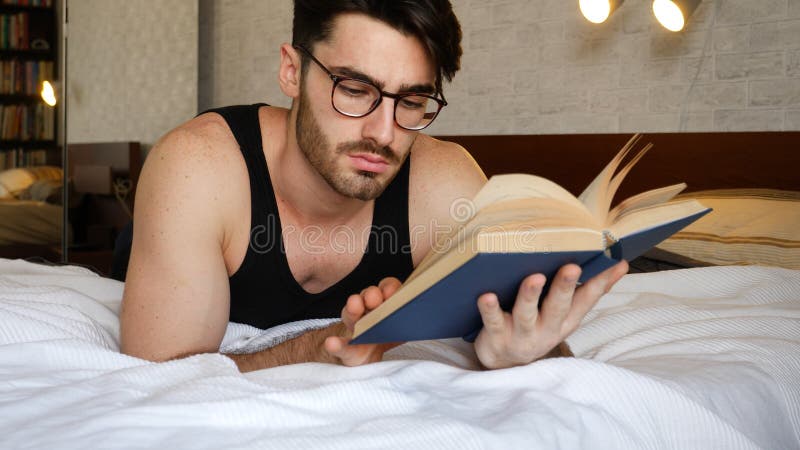 Young Man Lying in Bed and Reading a Book Stock Photo - Image of relax ...