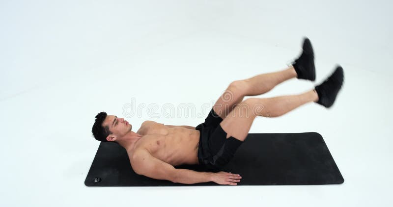 Young Man Making Abdominal Exercises. Leg Movement Sitting on the Rug ...