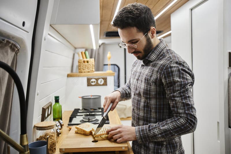 Young Man Making Breakfast in Tiny Kitchen at Trailer Van and Cutting ...