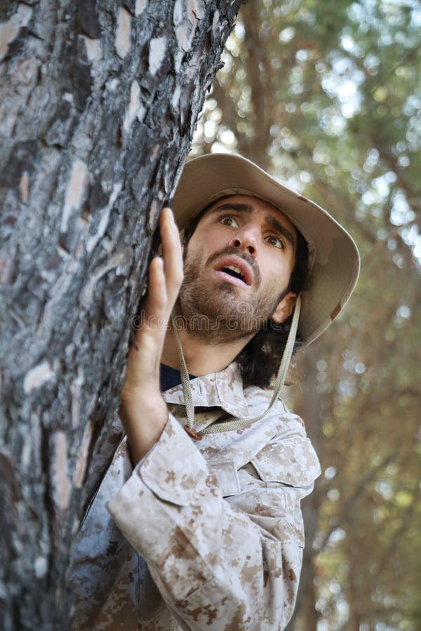 Scared Soldier Hides Behind the Trunk of a Tree in the Mountains from ...