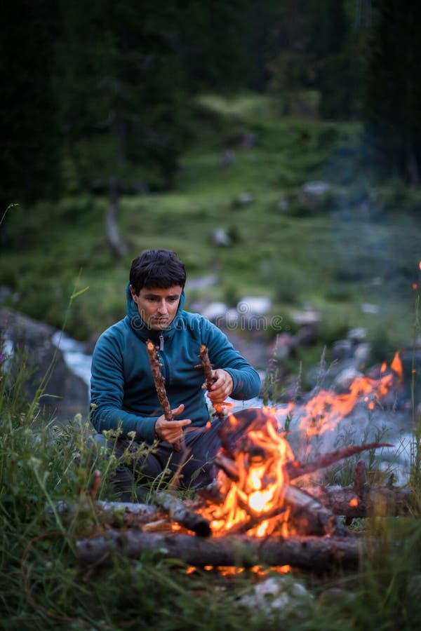 Young Man Making Fire while Camping Outdoors, Stock Image - Image of ...