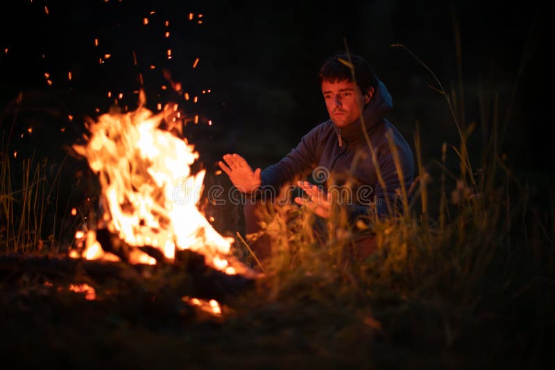 Young Man Making Fire while Camping Outdoors, Stock Image - Image of ...