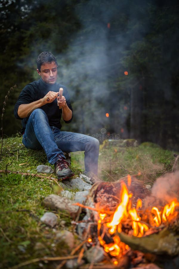 Young man by a campfire stock photo. Image of extreme - 176248688