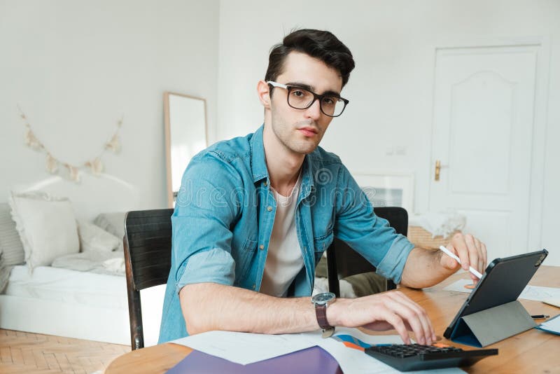 A Young Man Manages Finances from Home. Economist Works at Home ...