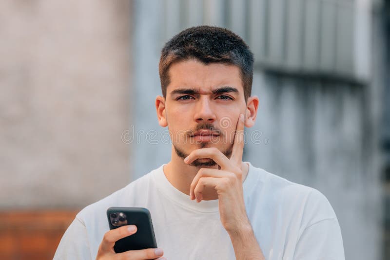 Man with Mobile Phone and Thoughtful Expression Stock Image - Image of ...