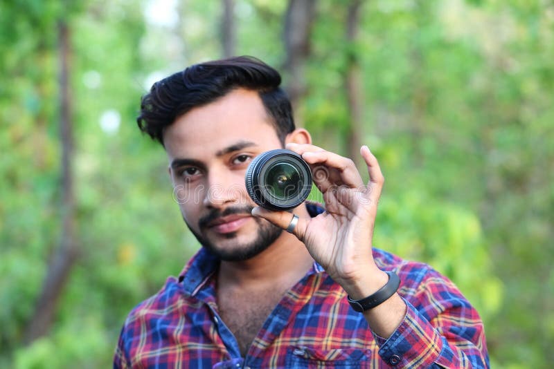 Young Man Model Holding a Camera Lens in Front of His Face with Focus ...