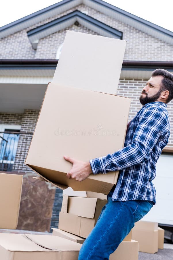 Young man moving into stock photo. Image of building - 119760316