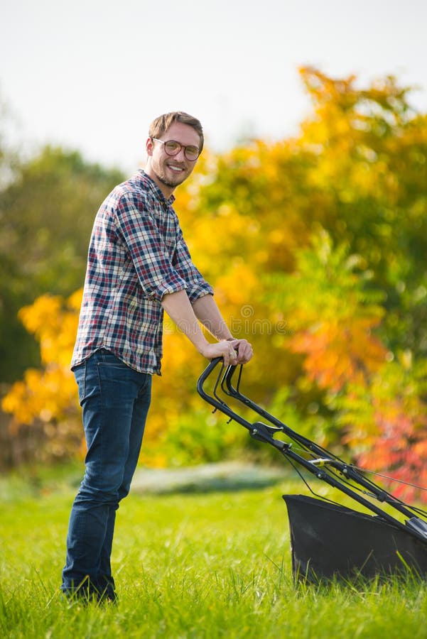 Young man mowing the grass stock photo. Image of maintenance - 78566100