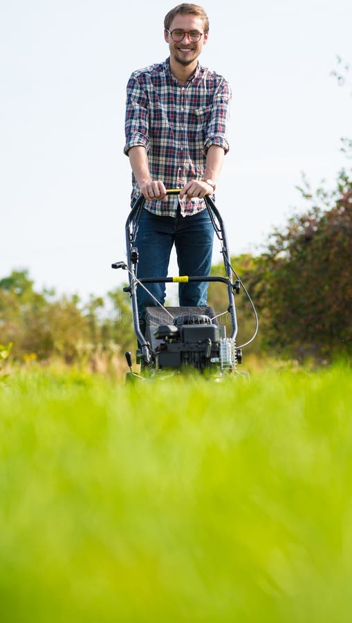 Young man mowing the grass stock image. Image of back - 78566291