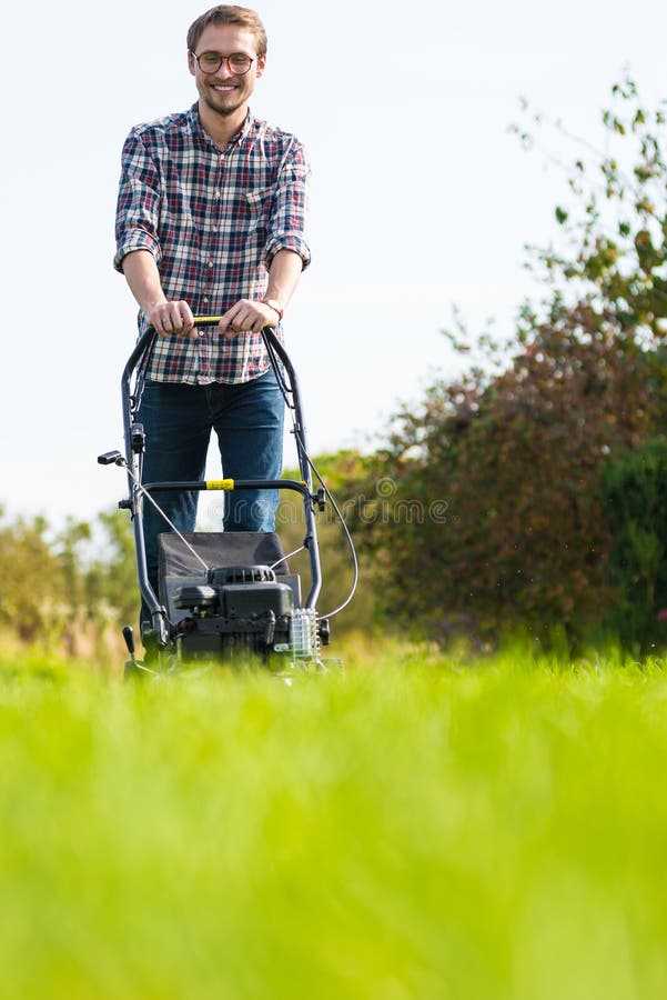 Young man mowing the grass stock image. Image of maintenance - 78566391