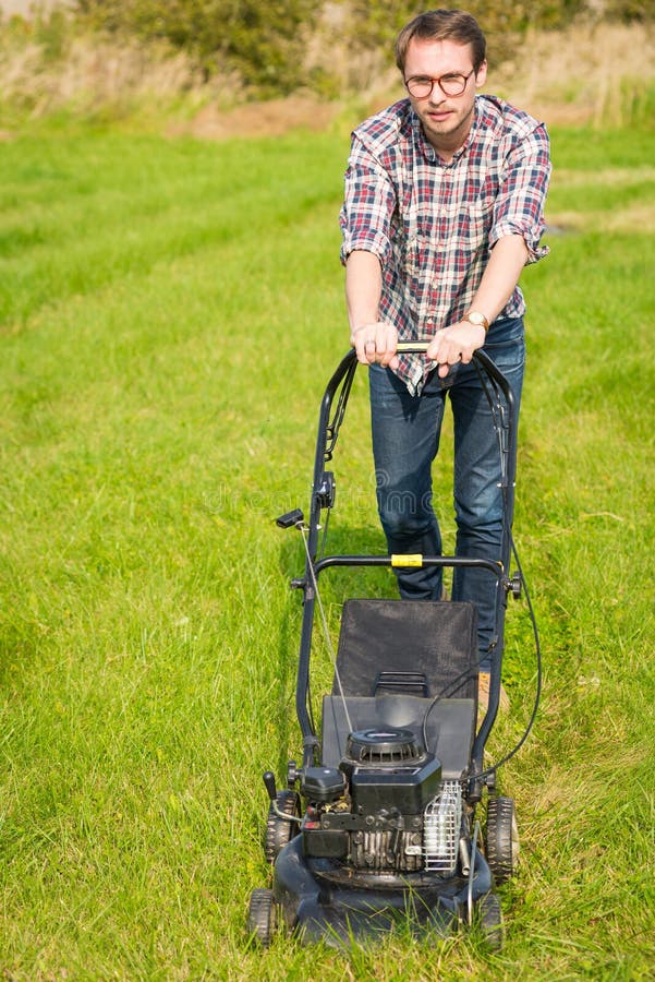 Young man mowing the grass stock image. Image of green - 78566591