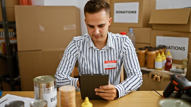 Young Man Named Alex Using Tablet Amidst Food Donations Inside a ...