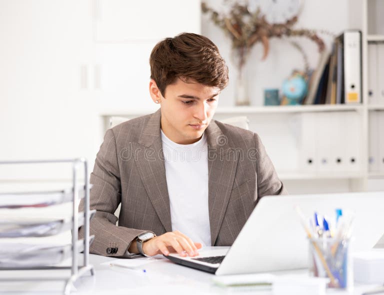Young Man Office Manager Sitting at Table and Using Laptop Computer ...