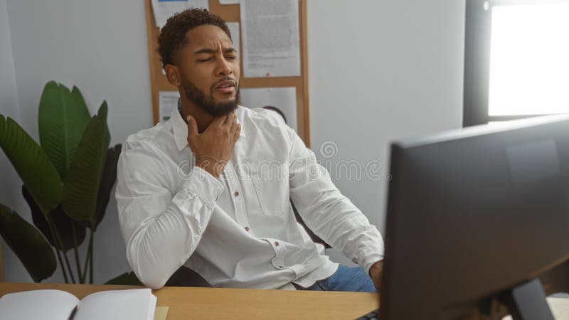 Young Man in Office Rubbing His Throat Looking Uncomfortable while ...