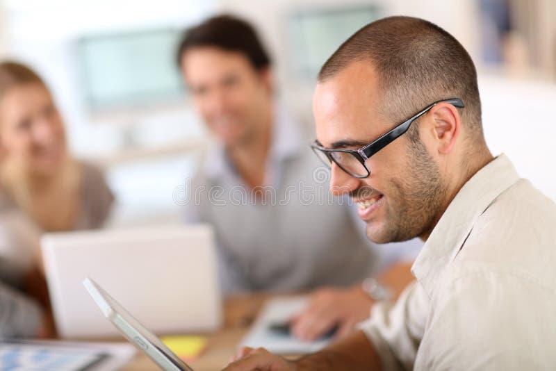 Young Man at Office Working, Coworkers in the Back Stock Image - Image ...