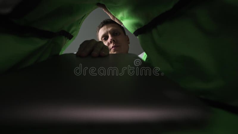 Young Man Opening Backpack and Reaching for a Laptop, Viewed from ...