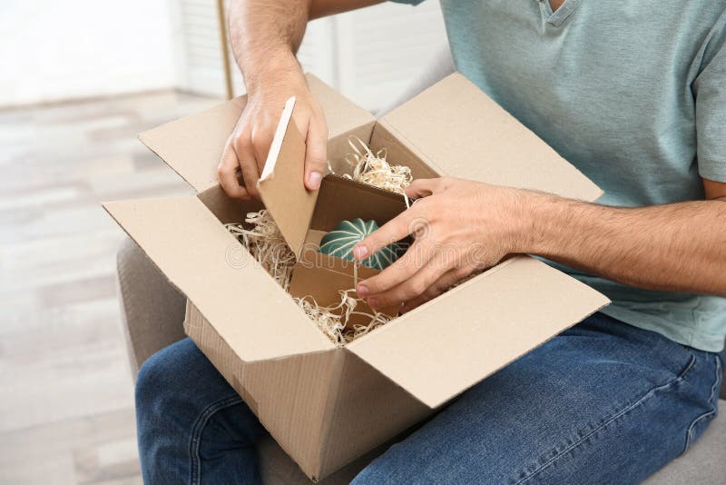Young Man Opening Parcel at Home Stock Image - Image of background ...