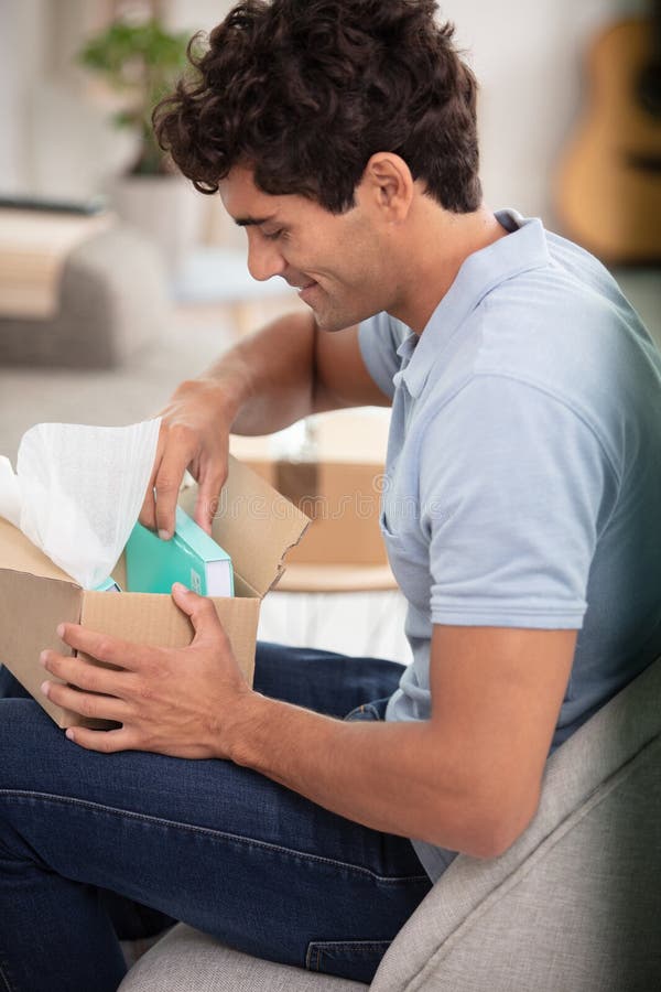Young Man Opening Parcel at Home Stock Image - Image of post, opening ...