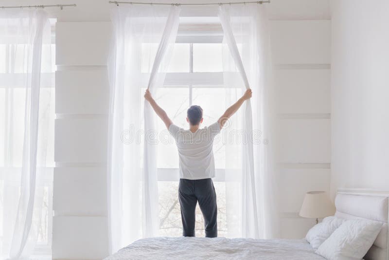Young Man Opening Window Curtains Stock Image - Image of conceptual ...