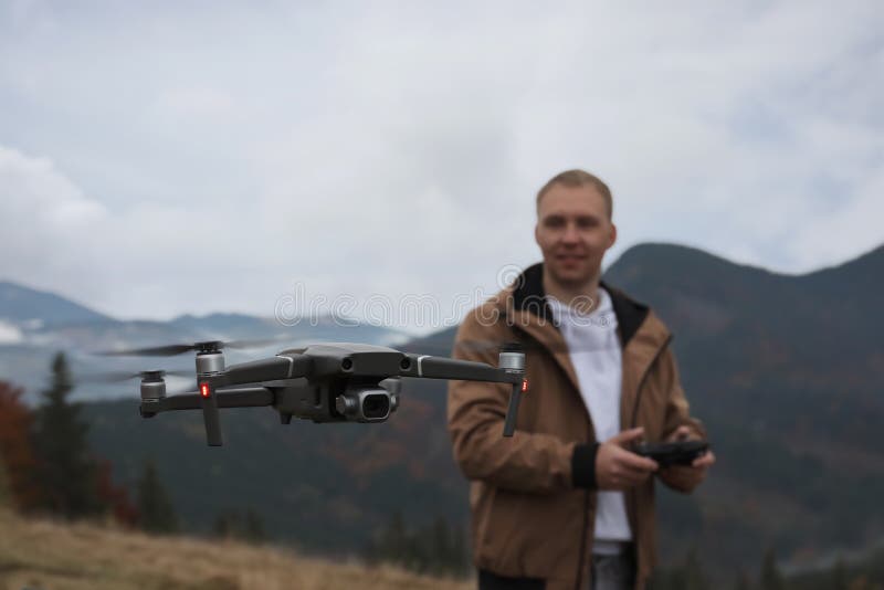 Young Man Operating Modern Drone with Remote Control in Mountains Stock ...