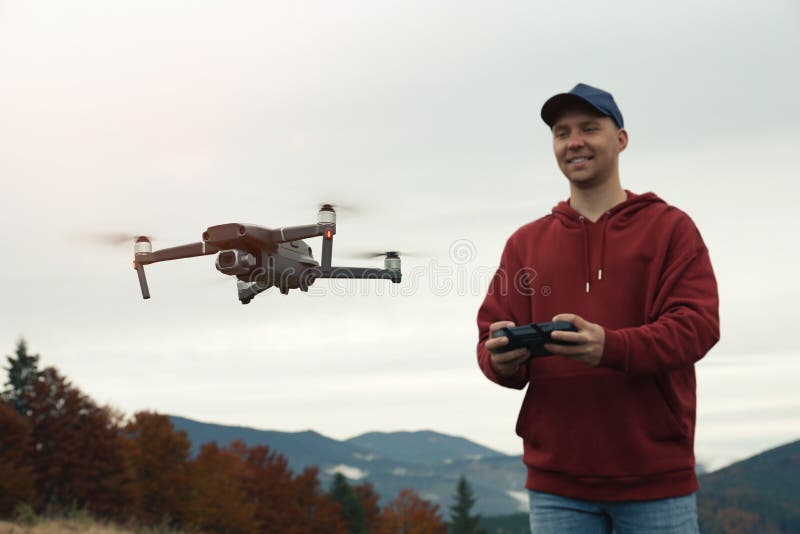 Young Man Operating Modern Drone with Remote Control in Mountains Stock ...
