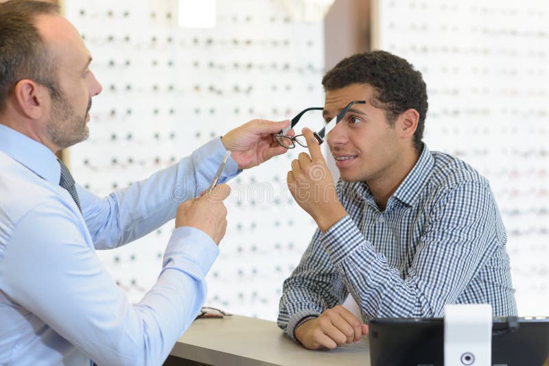 Young Man in Opticians Trying on Glasses Stock Image - Image of care ...