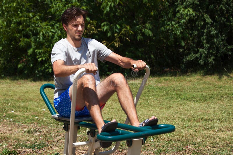 Young Man Outdor Exercise on Rowing Machine Stock Photo - Image of ...