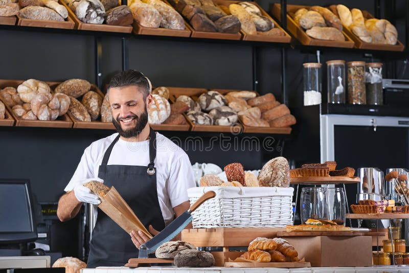 Young Man Packaging Bread for Customer in Bakery Stock Photo - Image of ...