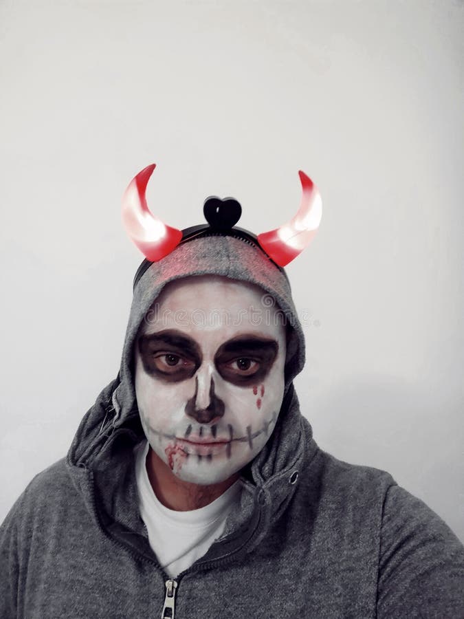 A Young Man with a Painted Skull on His Face on a White Background ...