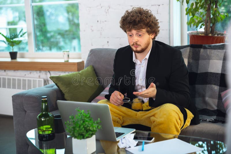 Young Man in Pajama and Jacket Working on a Computer, Laptop. Remote ...